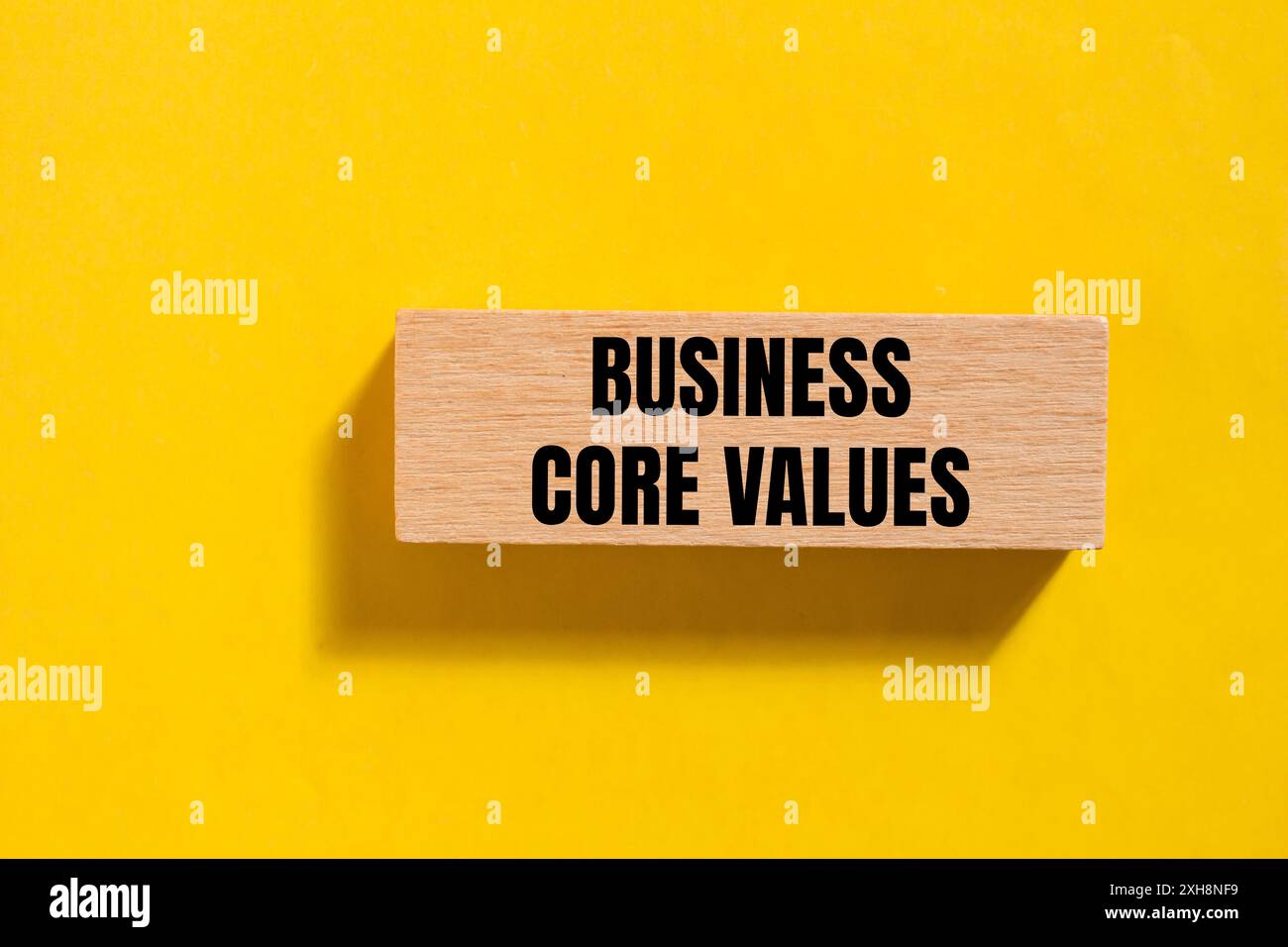 Business core values message written on single wooden block with yellow ...