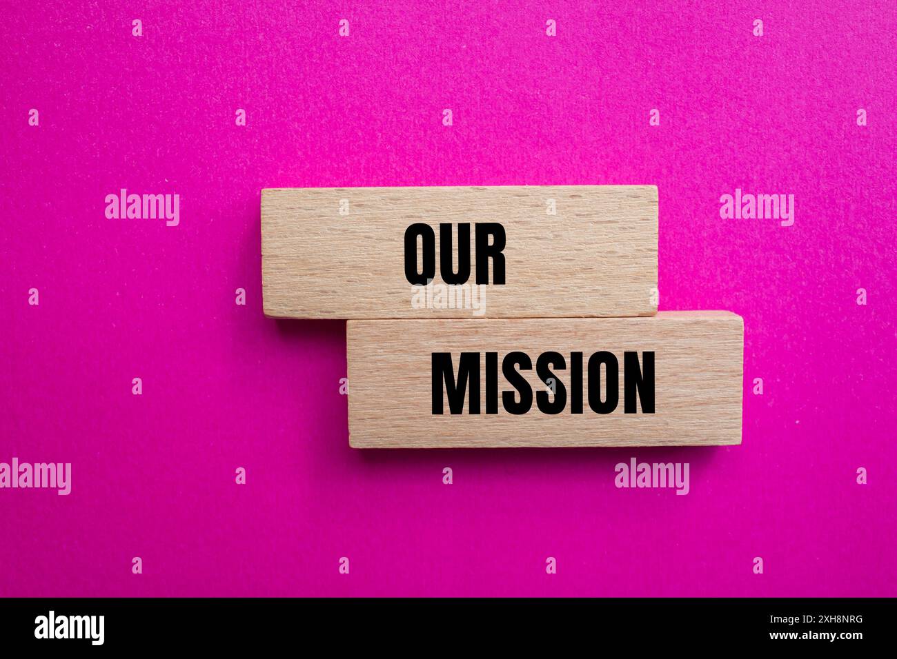 Our mission message written on wodoen blocks with pink background ...