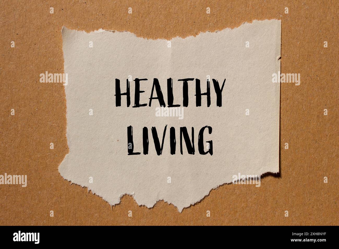 Healthy living message written on ripped paper with cardboard ...