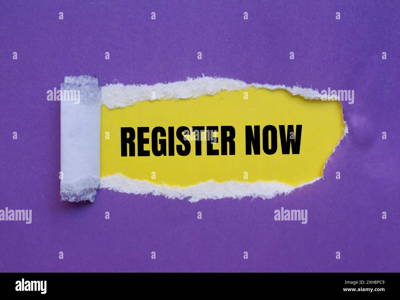 Register now message written on ripped torn purple paper with yellow ...