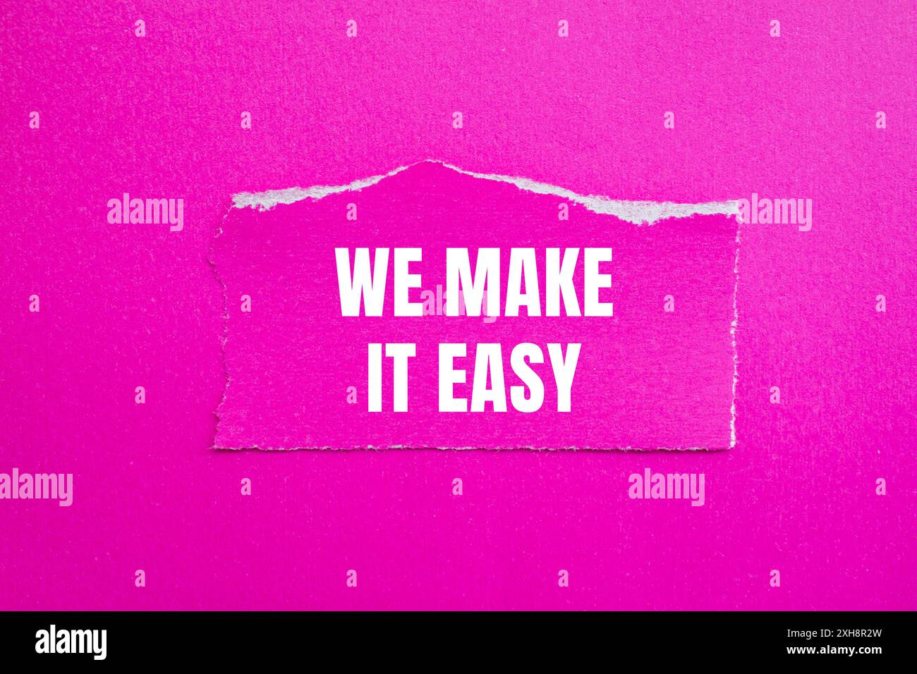 We make it easy message written on ripped torn pink paper piece with pink background. Conceptual ...