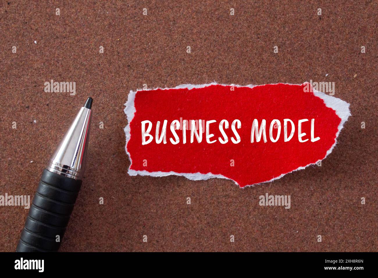 Business model message written on ripped torn red paper and a pen with ...