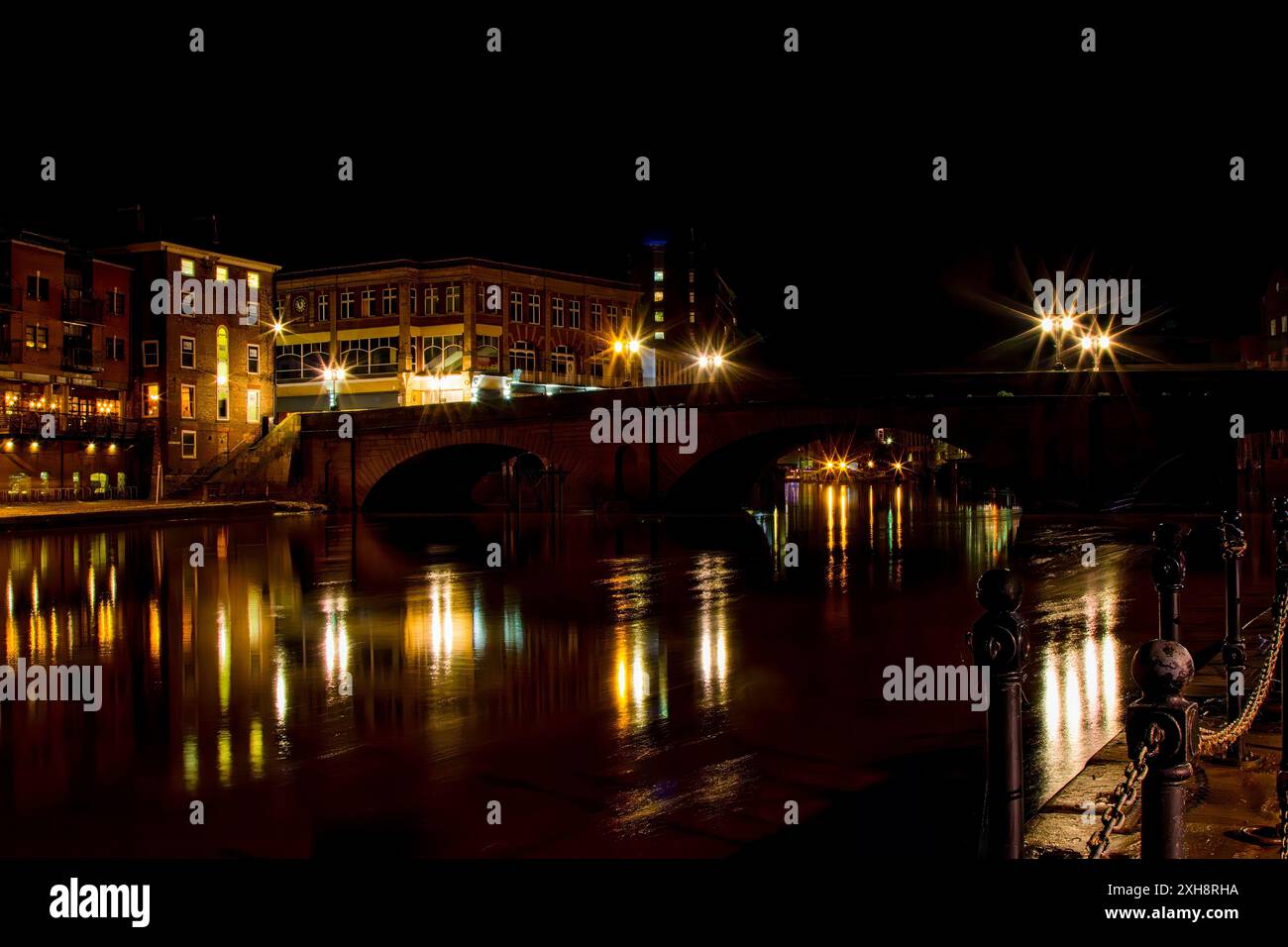 At night, the York City River Ouse glows, with buildings and bridges in ...
