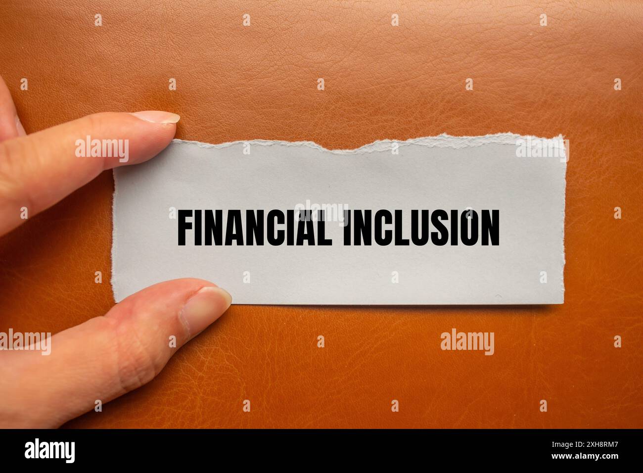 Financial inclusion message written on ripped paper piece with brown ...