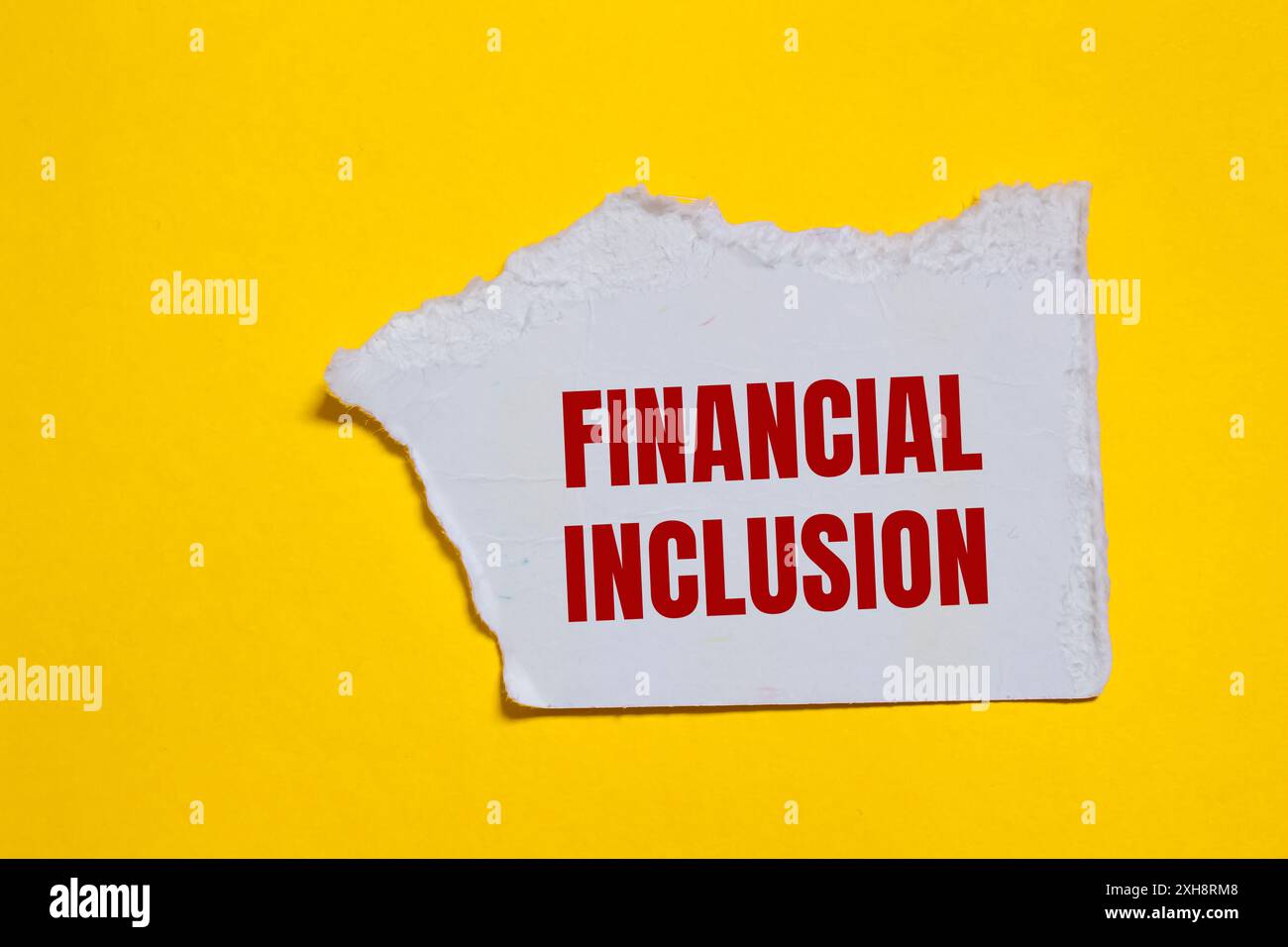 Financial inclusion words written on ripped torn white paper piece with ...