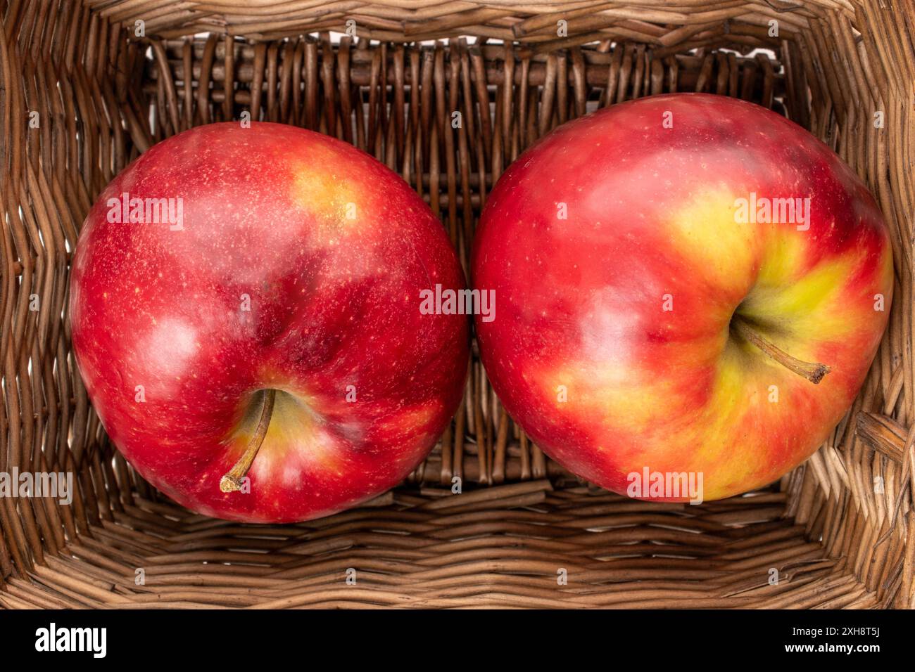 Two red apples in a vine basket, macro, top view Stock Photo - Alamy