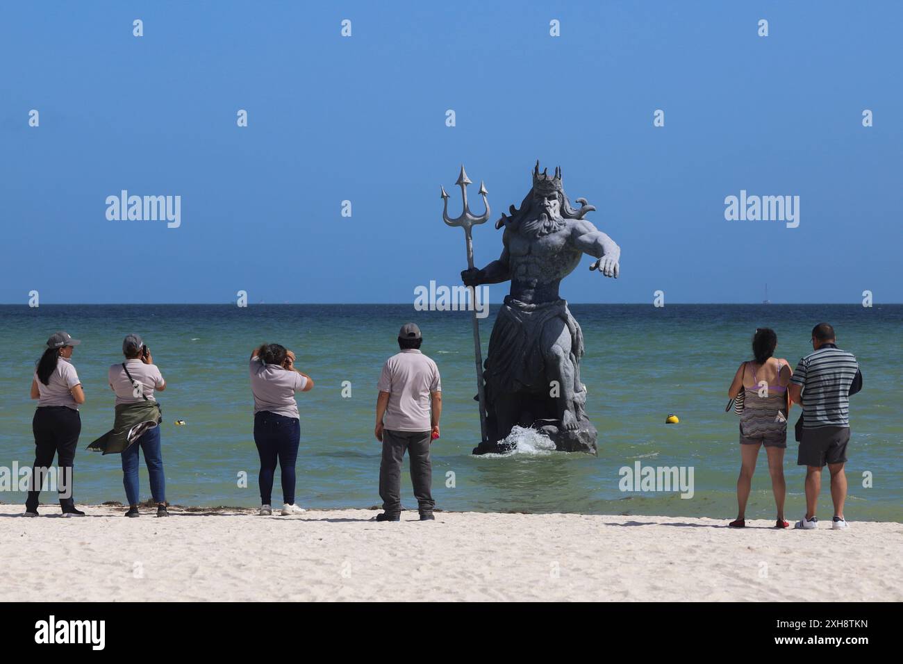 FILE - Tourists take pictures of Poseidon sculpture before the arrival ...