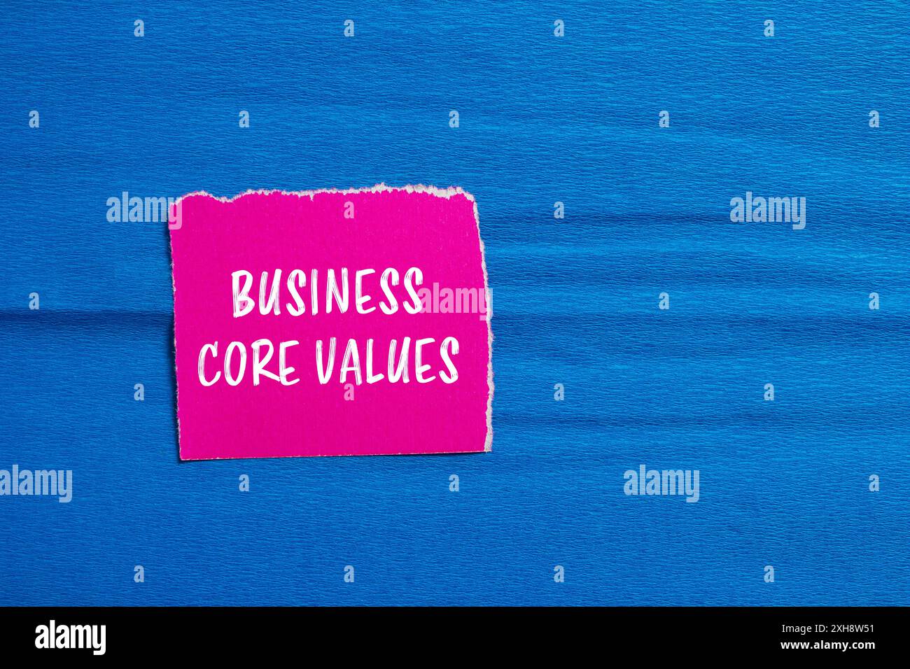 Business core values message written on ripped torn pink paper piece ...