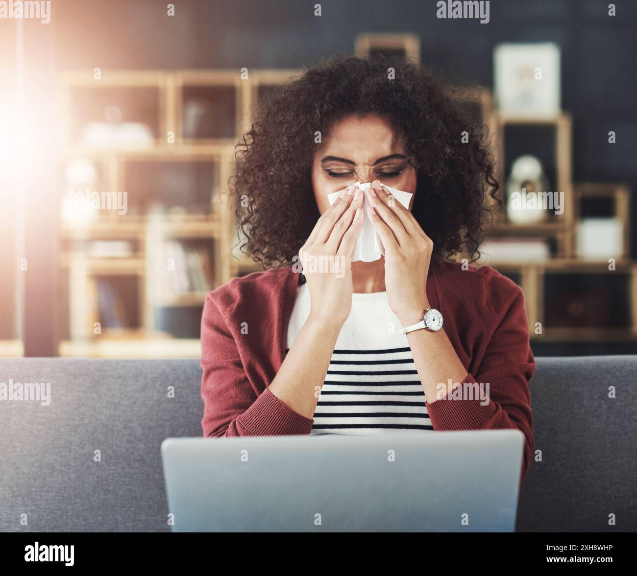 Tissue, laptop and woman on sofa blowing nose for flu, sinus or viral ...