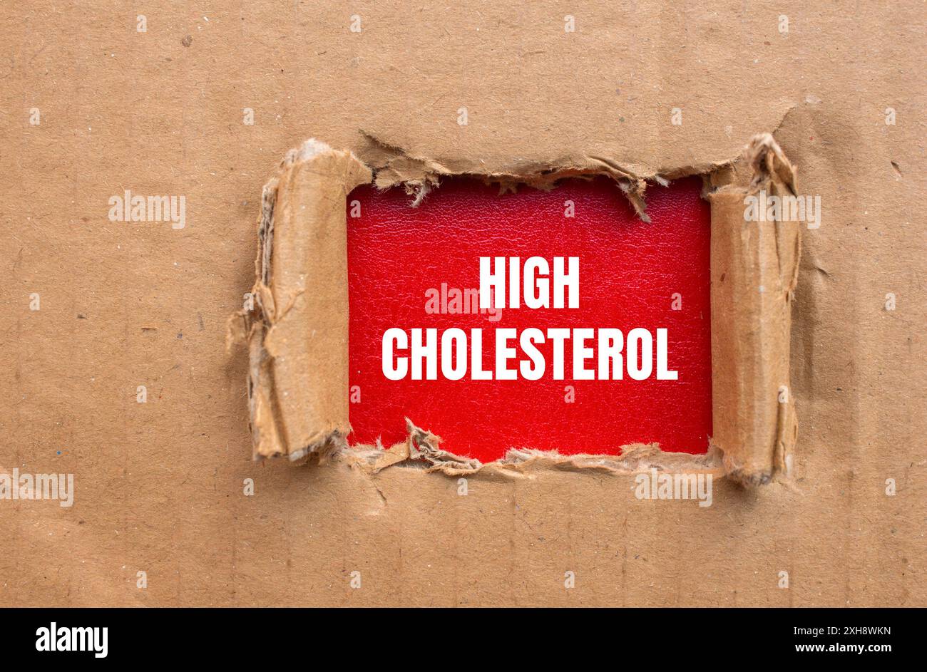 High cholesterol message written on ripped cardboard paper with red background. Conceptual high ...