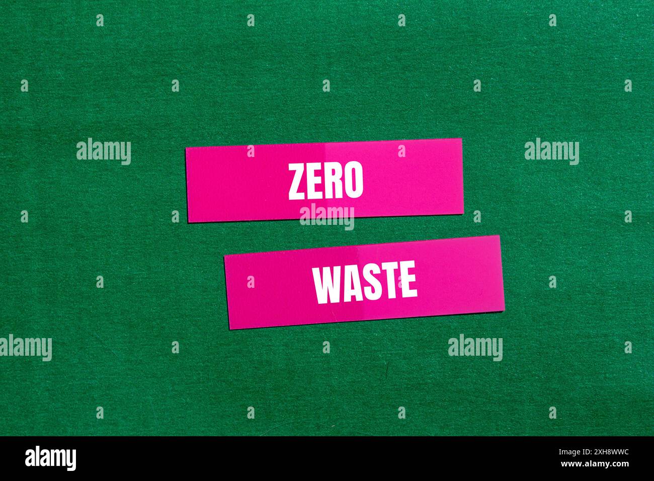 Zero waste message written on pink paper with green background. Conceptual zero waste symbol ...