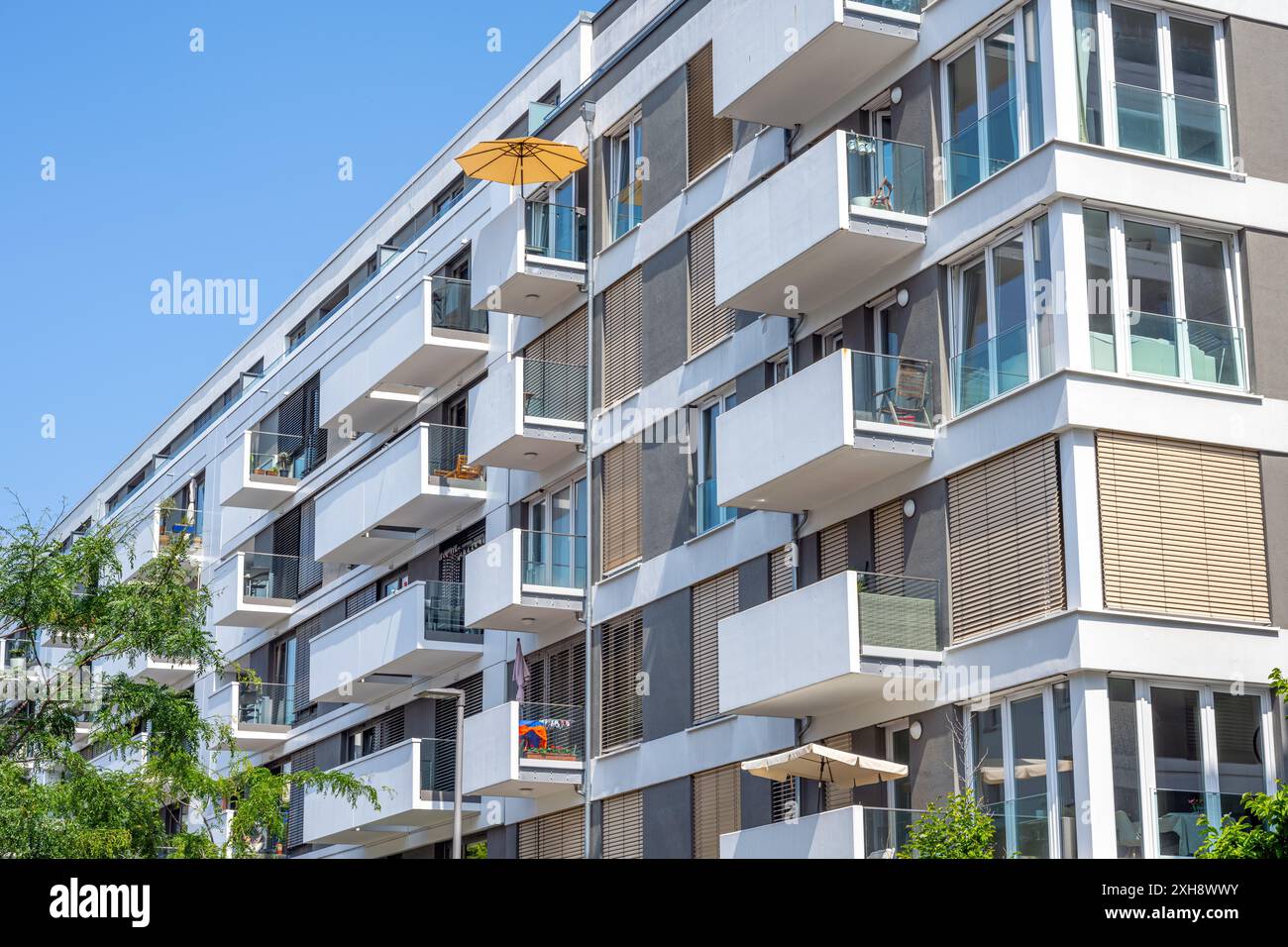 Modern multi-family apartment building with a yellow parasol seen in ...
