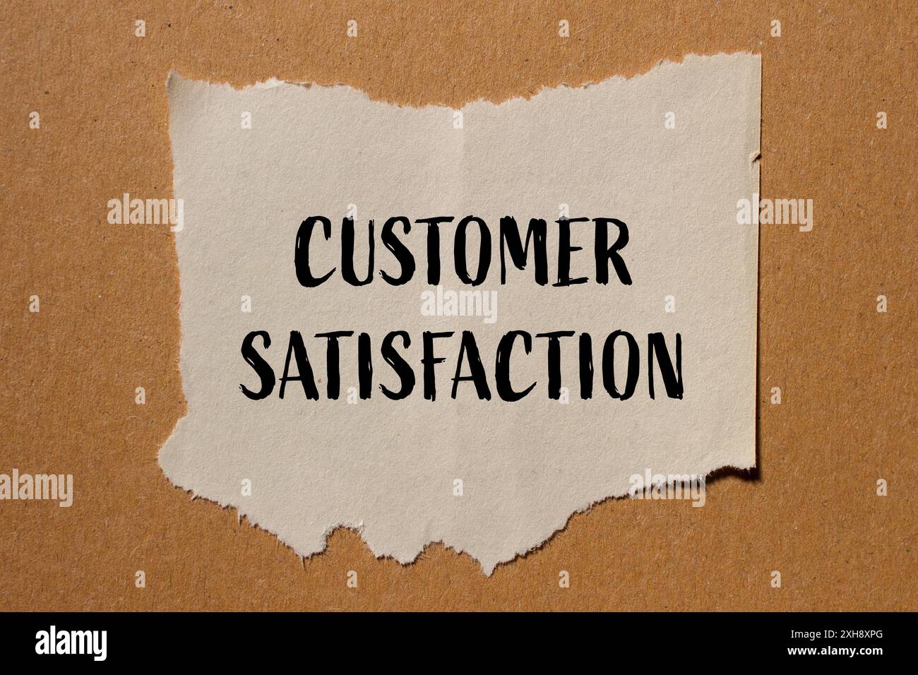 Customer satisfactionmessage written on ripped paper with cardboard ...