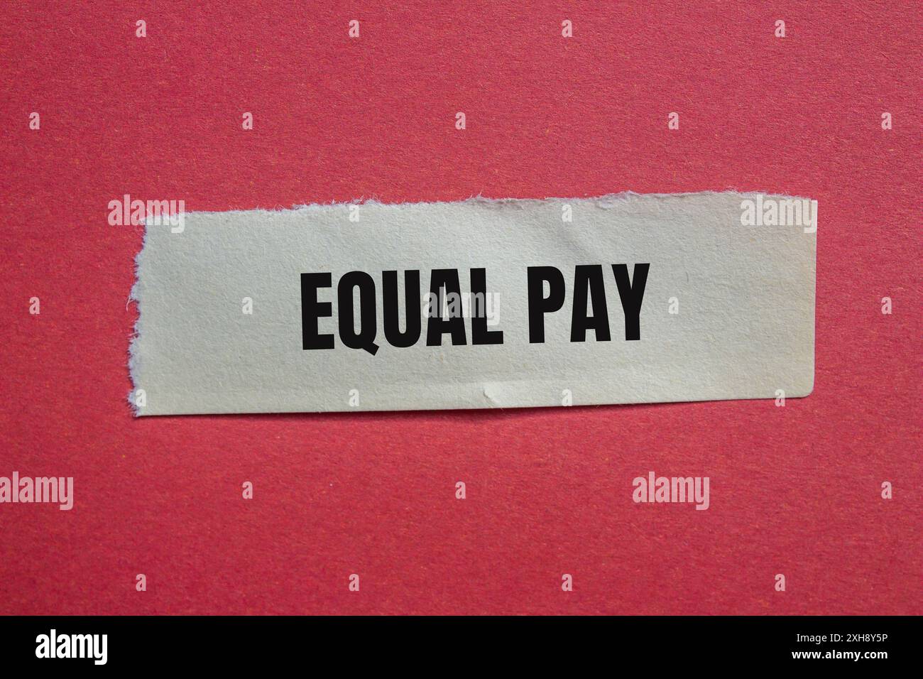 Equal pay message written on ripped paper with red background ...