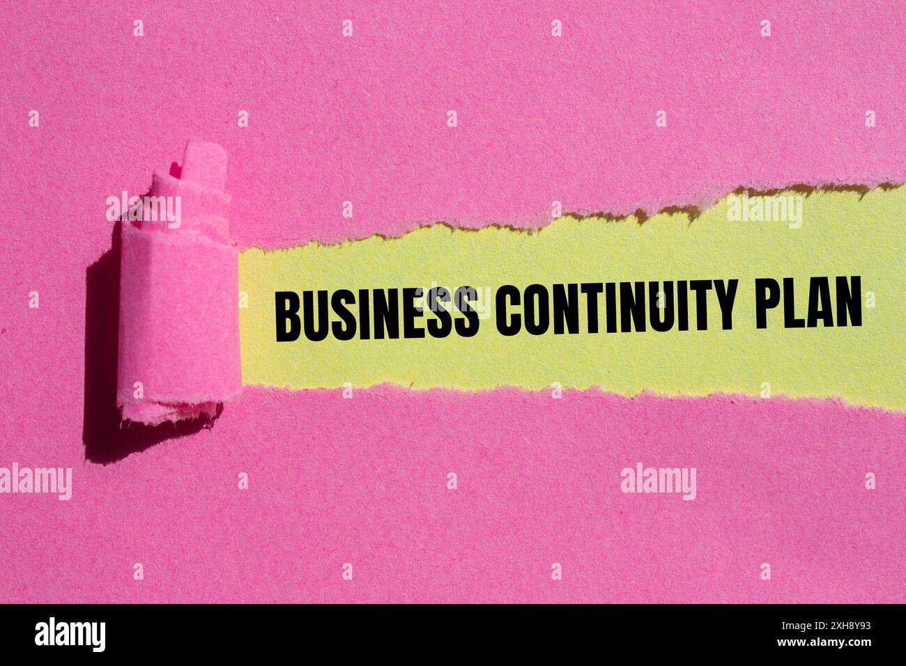 Business continuity plan message written on ripped pink paper with ...