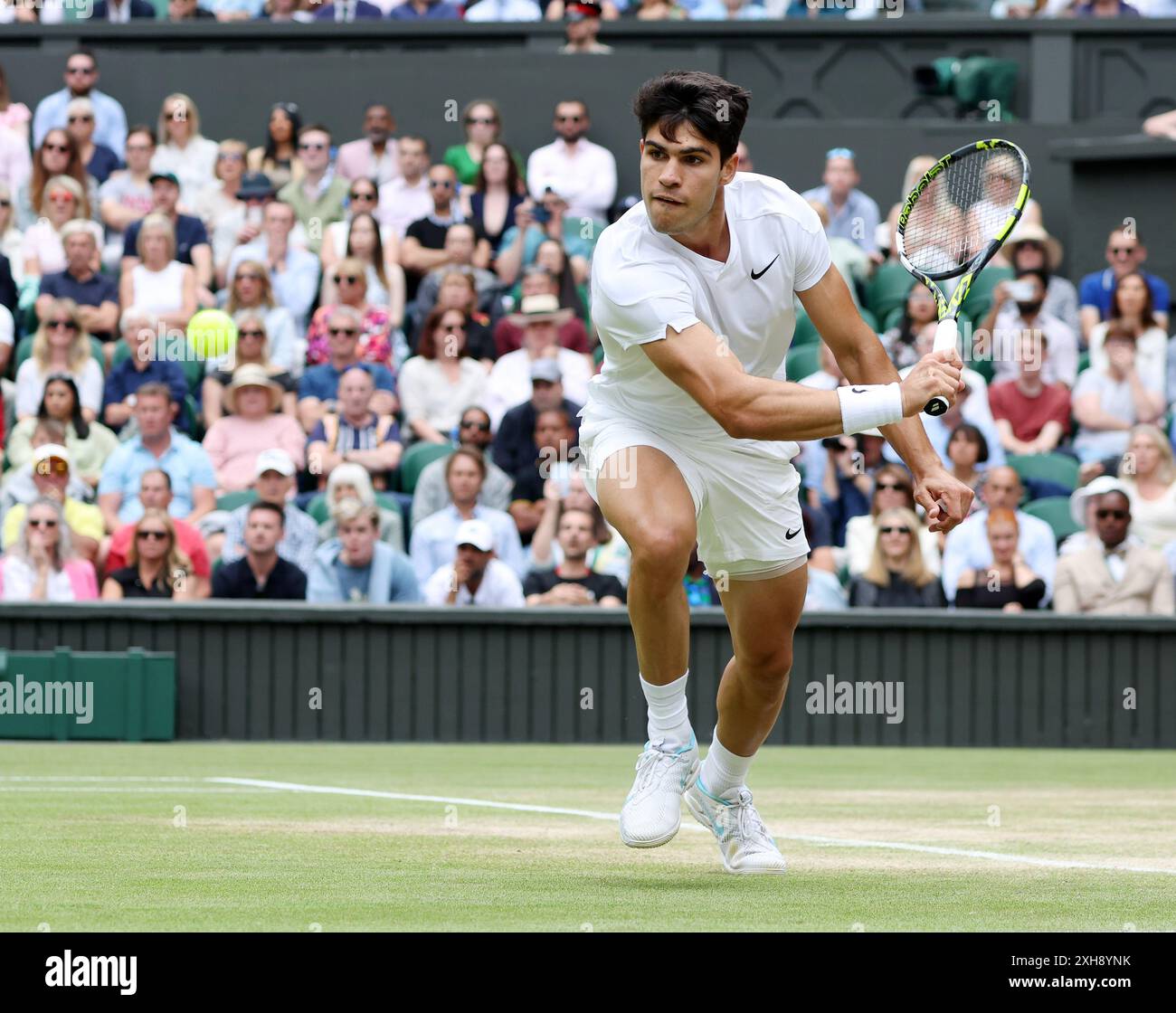 London, UK. 12th July, 2024. Carlos Alcaraz plays a forehand in his Men ...