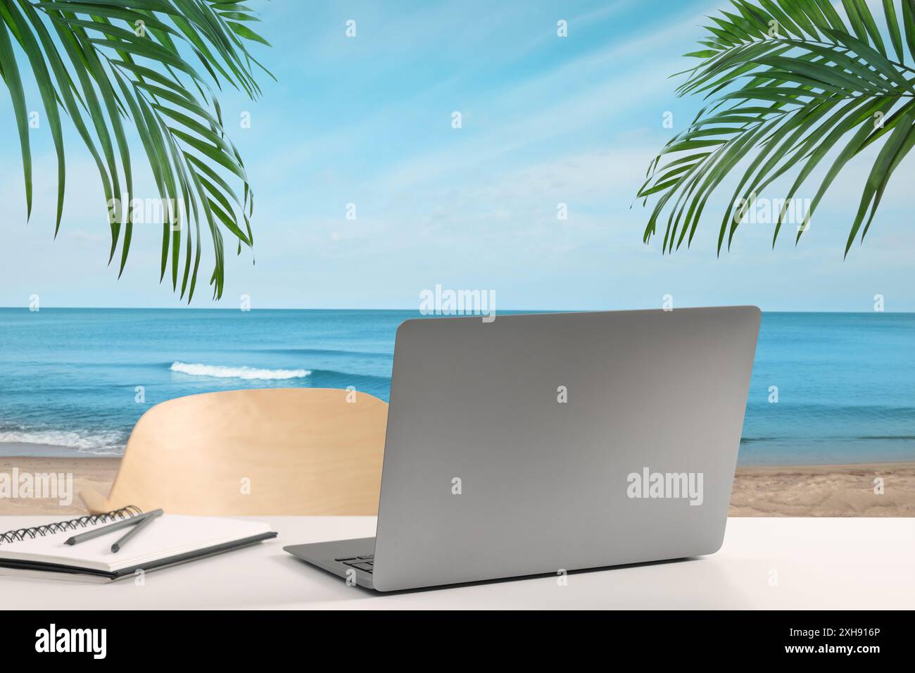 Workplace at beach, distant office. Table with laptop and chair on ...