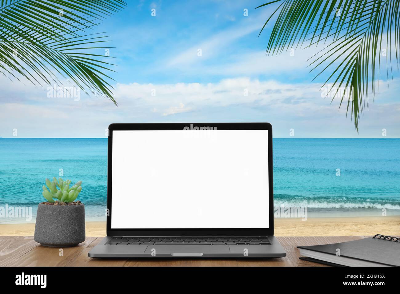 Workplace at beach, distant office. Table with laptop on sandy seashore ...