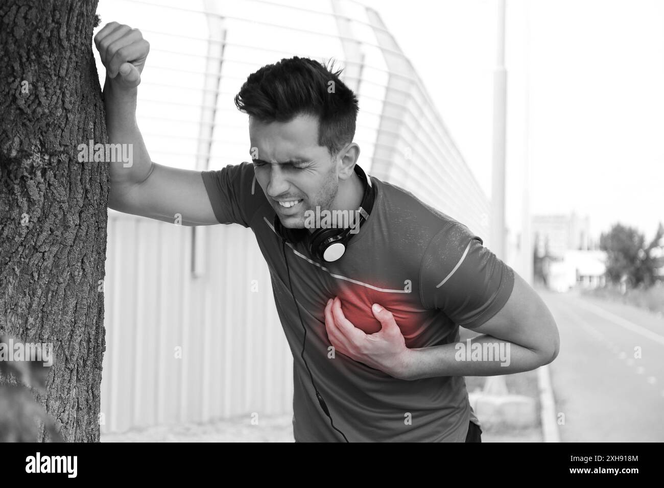 Heart attack. Man writhing in pain and pressing hand to chest outdoors ...