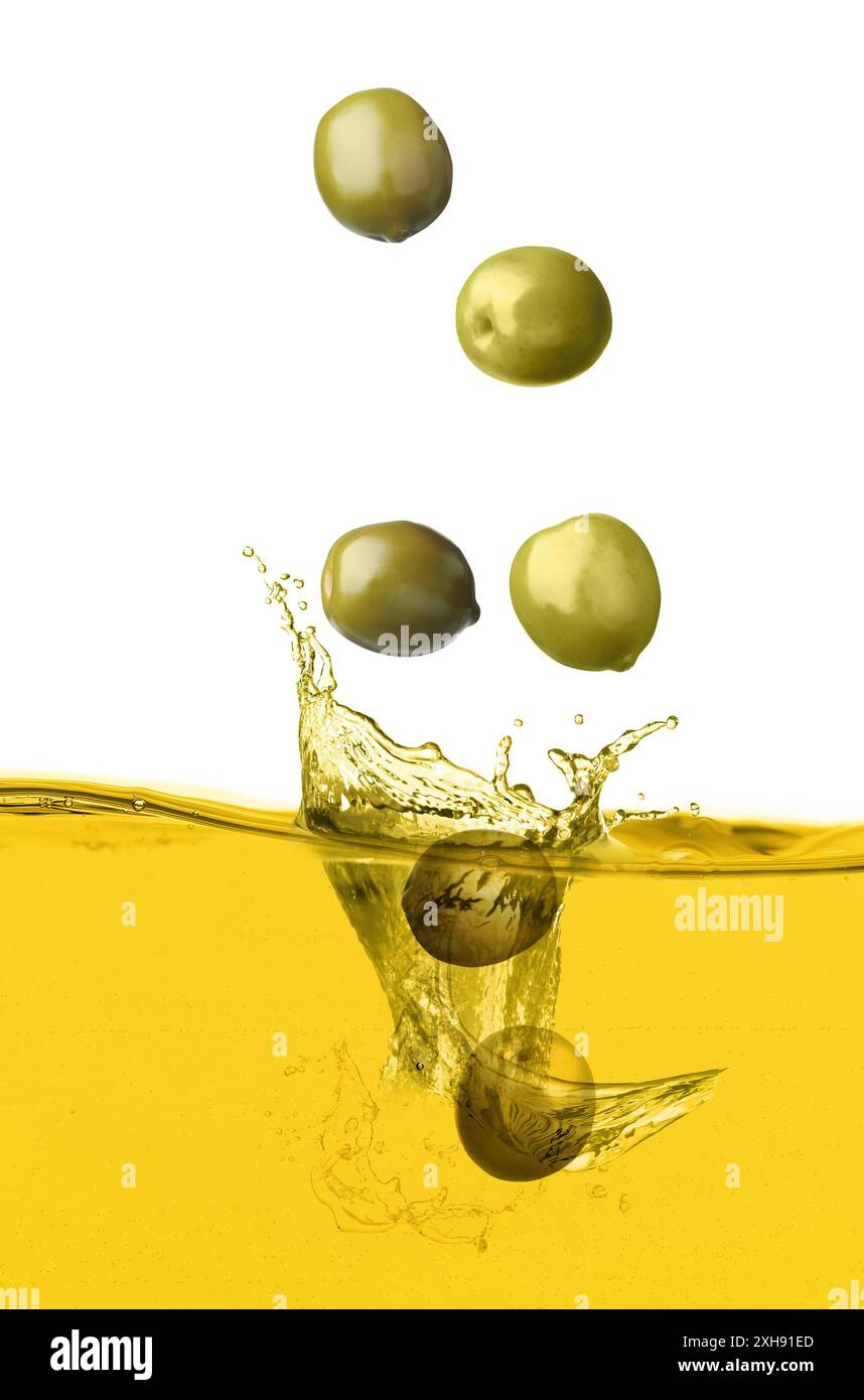Green olives falling into cooking oil on white background Stock Photo ...