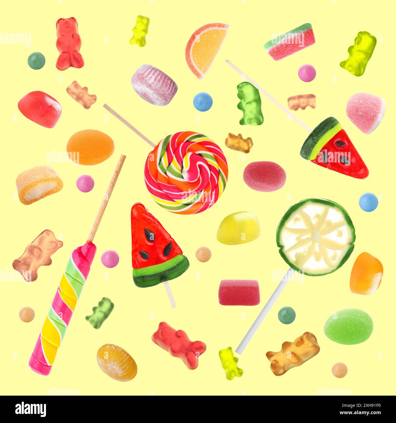 Different sweet candies in air on yellow background Stock Photo - Alamy