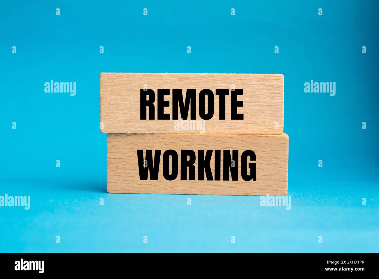 Remote working message written on wooden blocks with blue background. Conceptual remote working ...