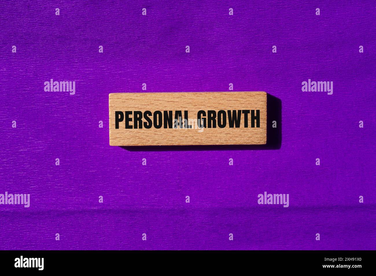Personal growth message written on wooden blocks with purple background ...