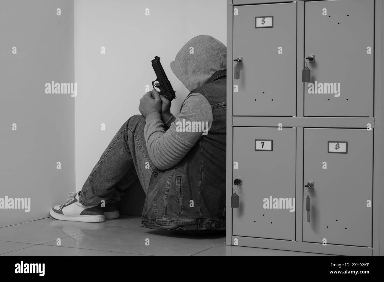 Male student with gun near locker. School shooting concept Stock Photo ...
