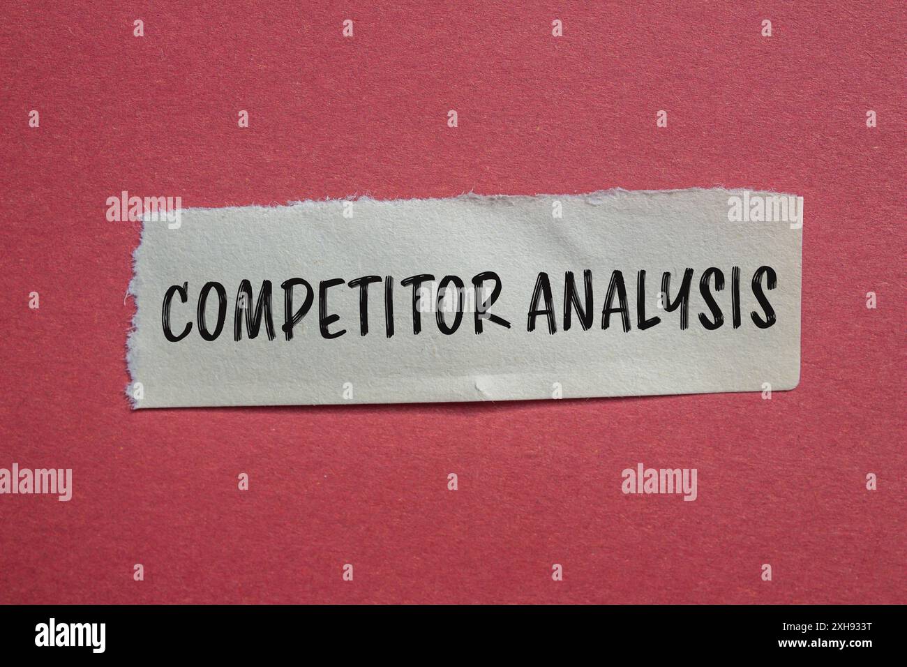 Competitor analysis message written on ripped paper with red background ...