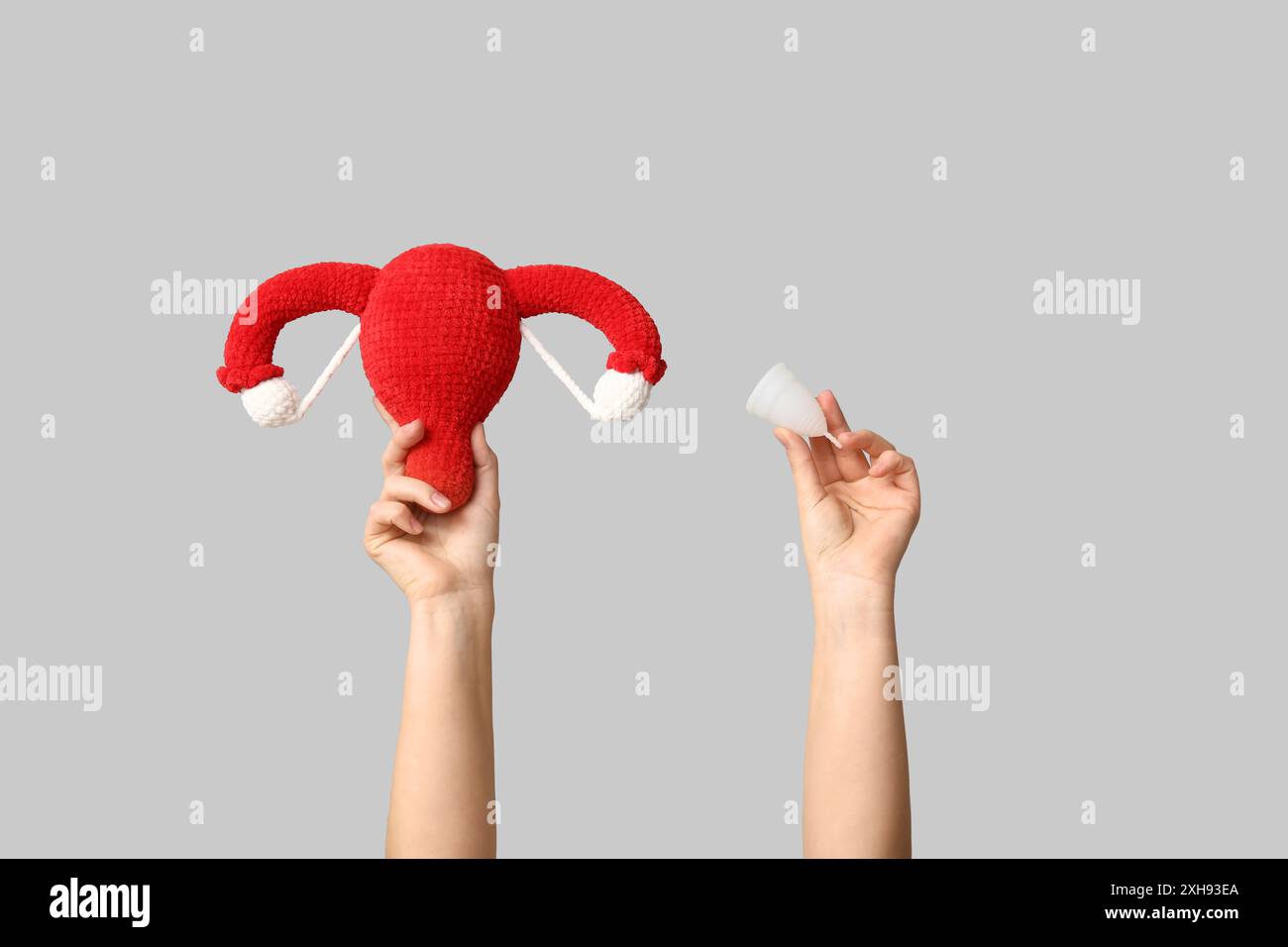 Hands with female uterus and menstrual cup on grey background Stock ...