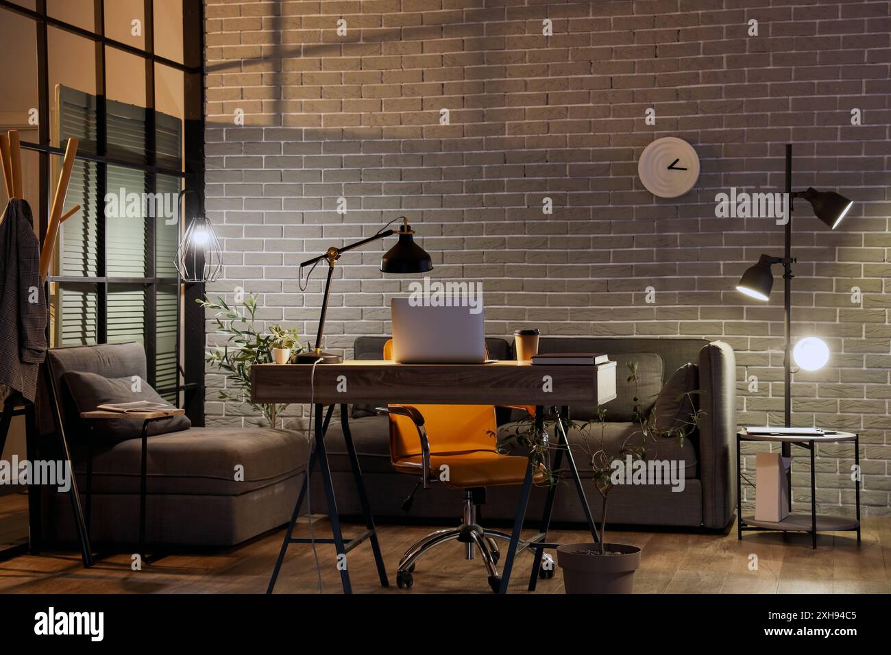 Interior of dark office with workplace, sofa and glowing lamps Stock ...