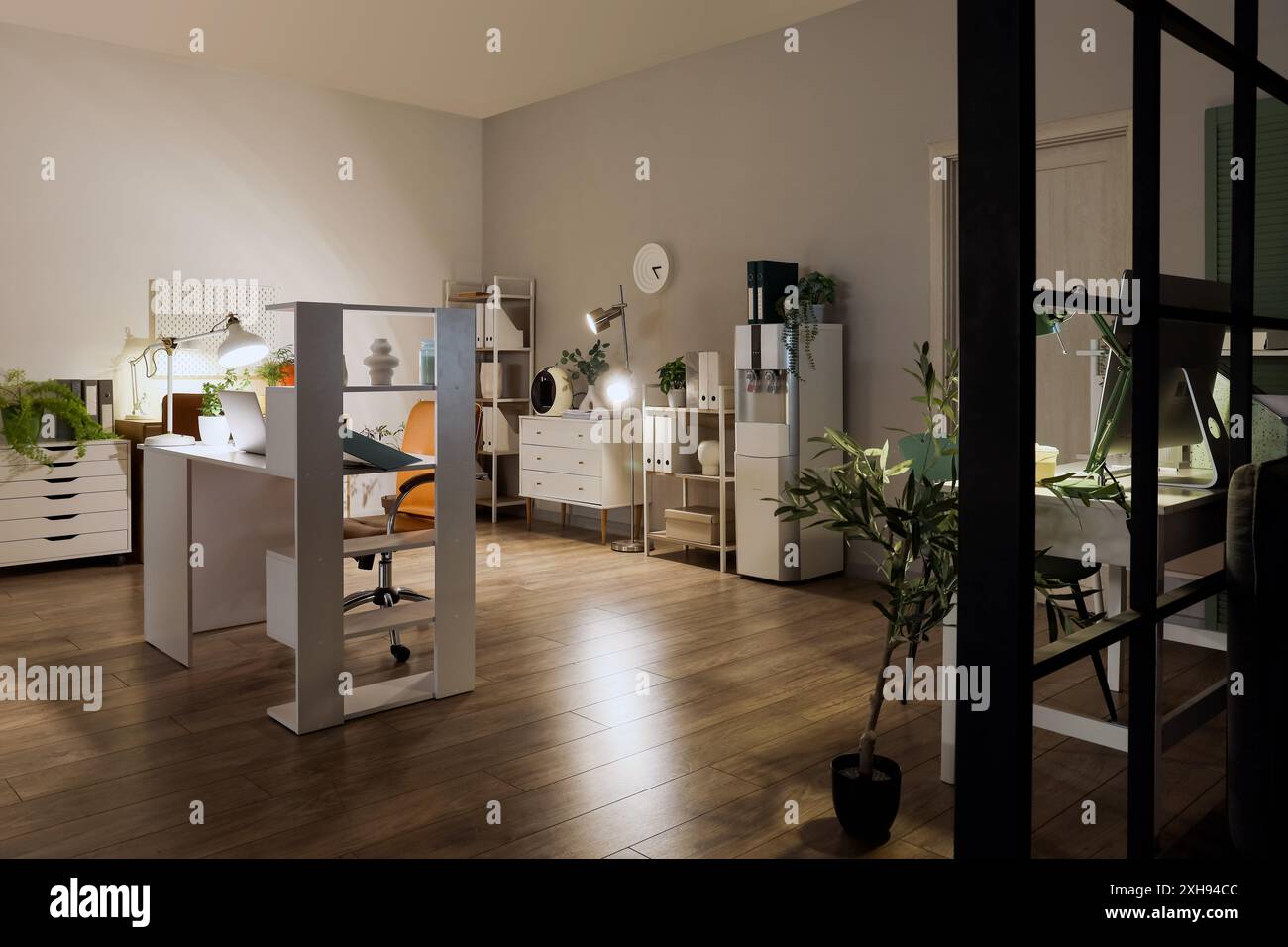 Interior of dark office with workplace, shelf units and glowing lamps ...