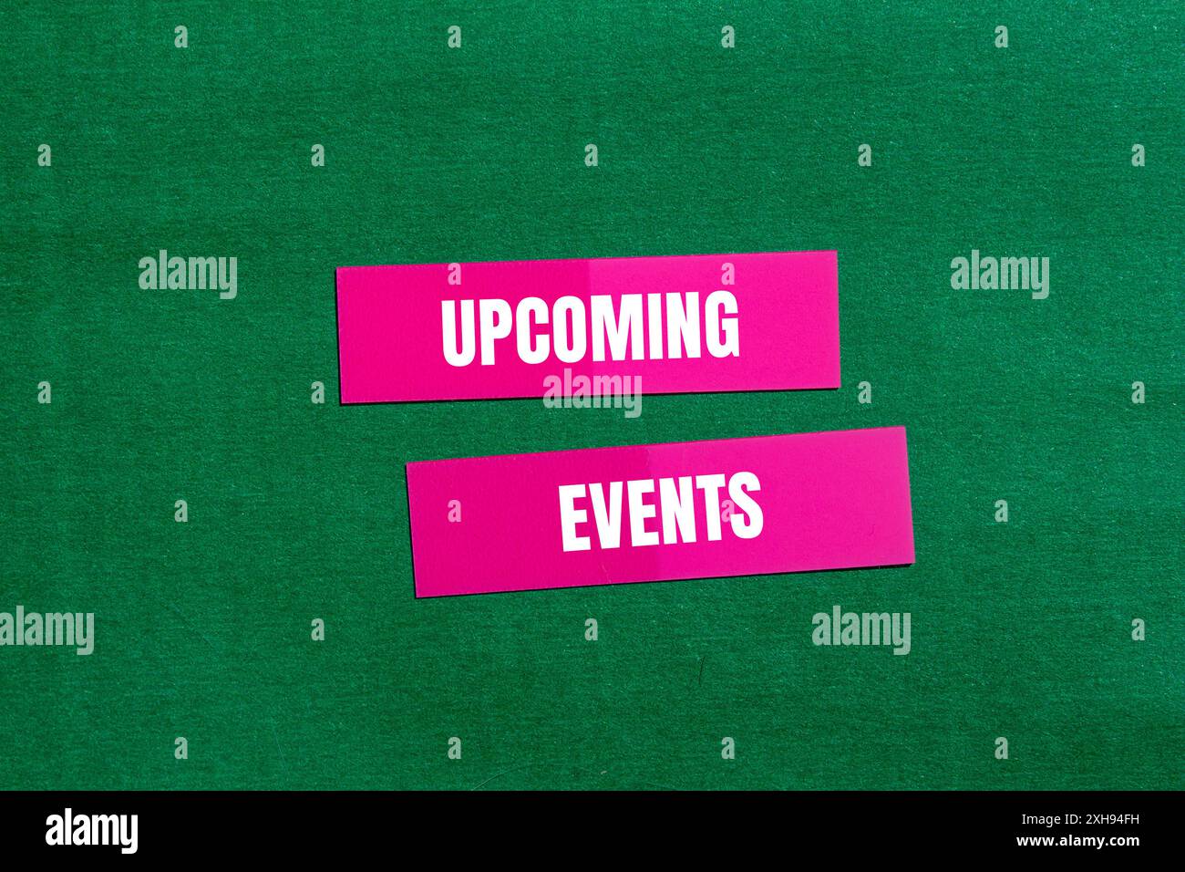 Upcoming events message written on pink paper with green background ...