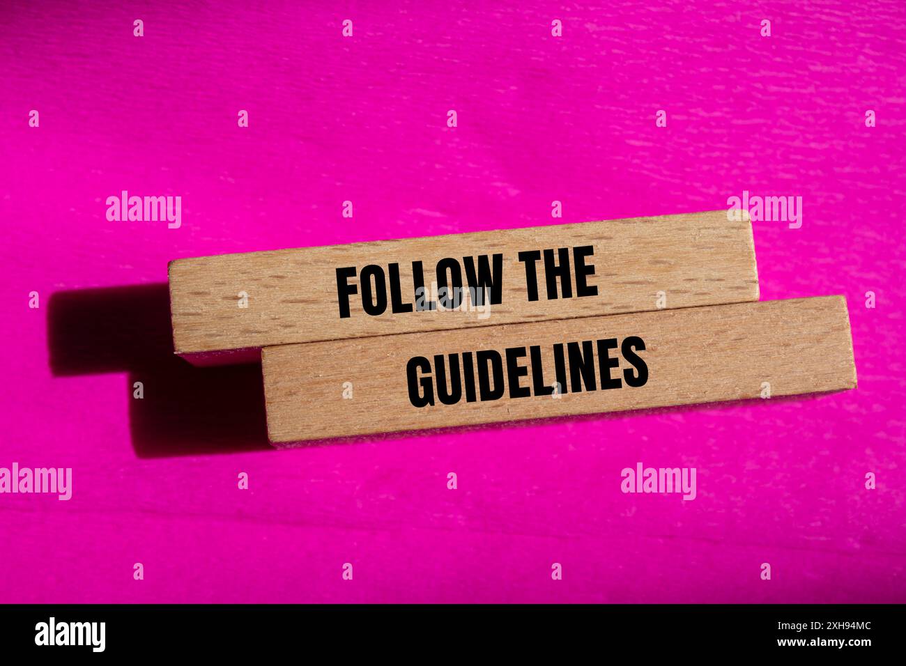 Follow the guidelines message written on wooden blocks with pink ...
