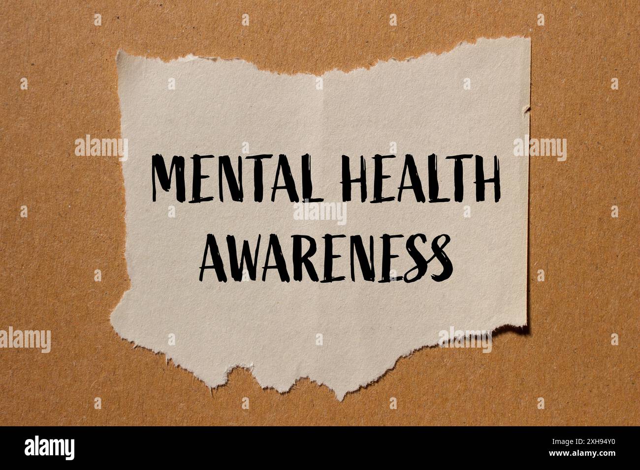 Mental health awareness message written on ripped paper with cardboard ...