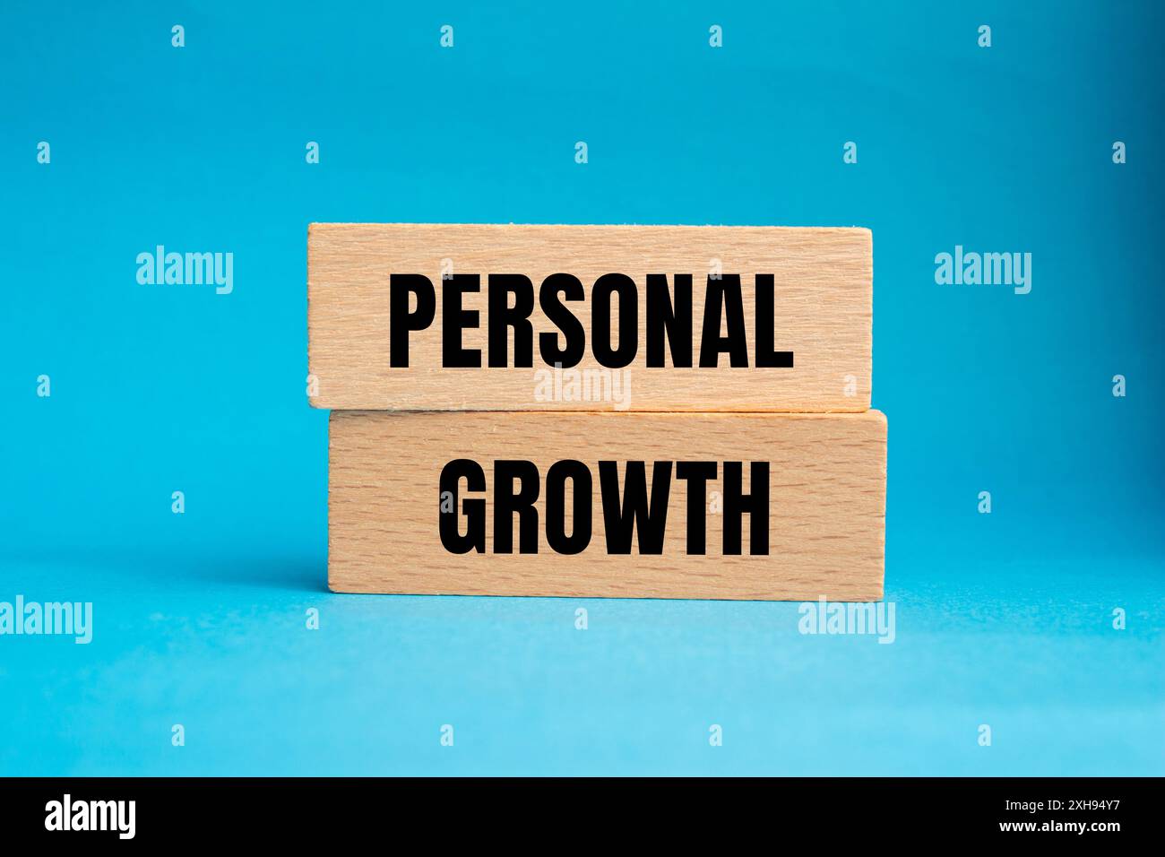 Personal growth message written on wooden blocks with blue background ...
