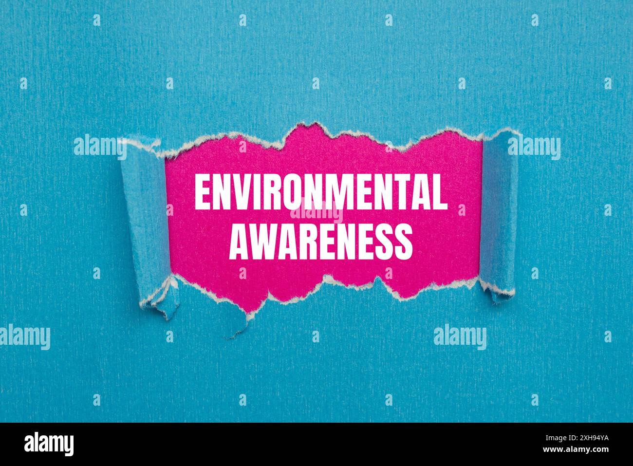 Environmental awareness message written on ripped blue paper with pink ...