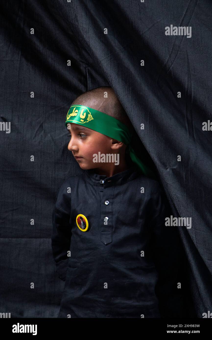 Srinagar, Kashmir, India. 12th July, 2024. A Kashmiri Shia boy stands ...