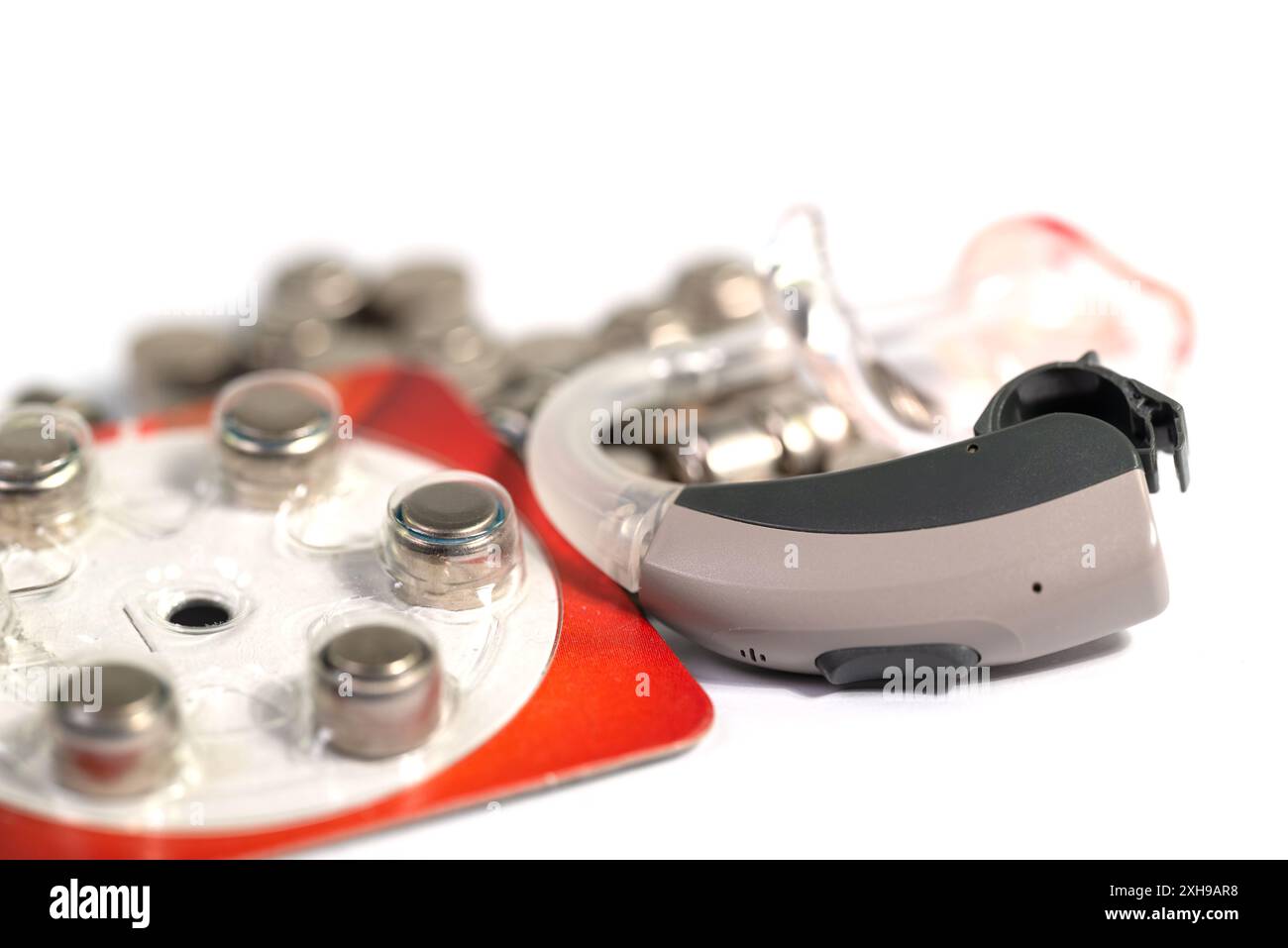 Button cells and hearing aid against a white background Stock Photo - Alamy