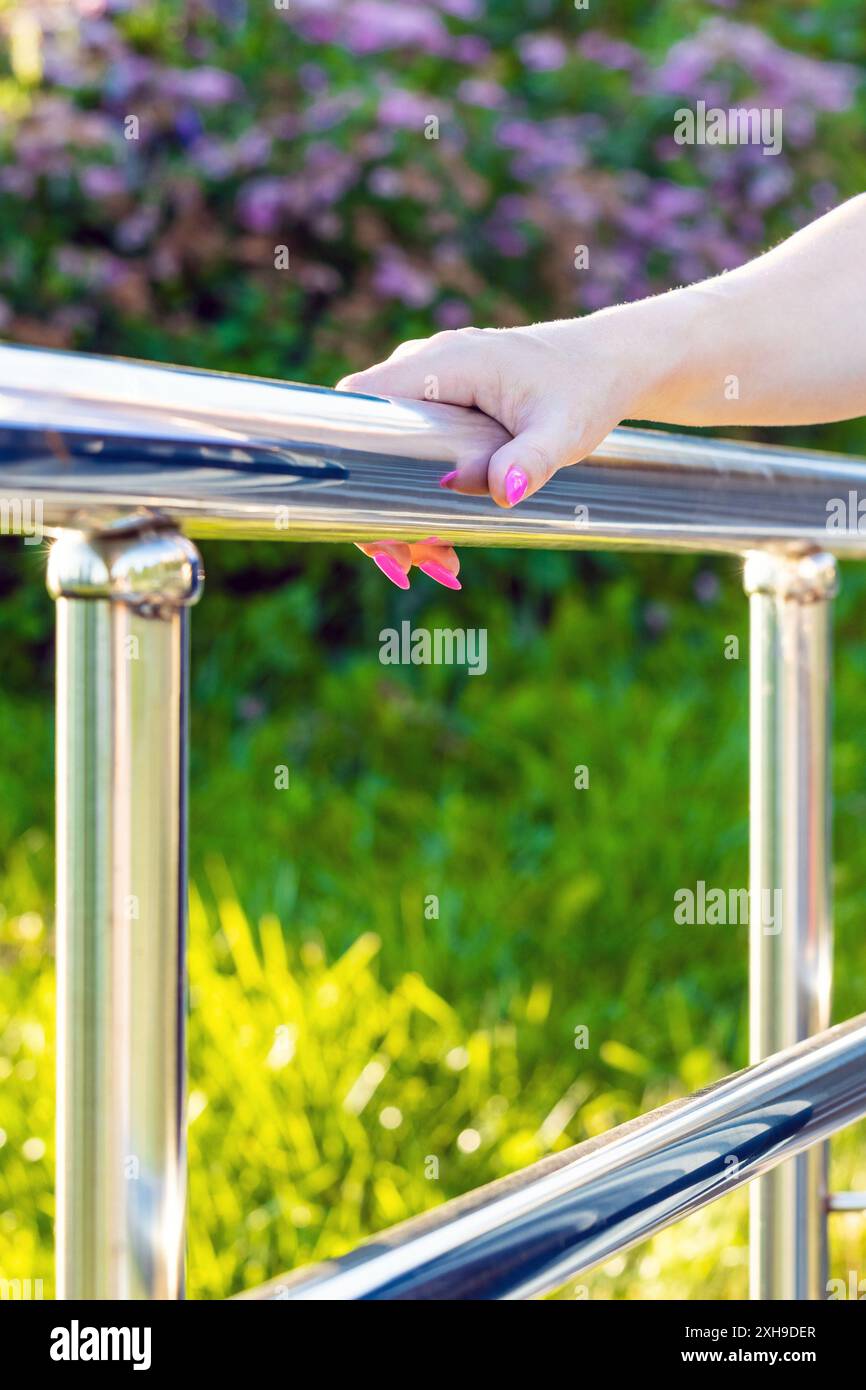 woman's hand holding onto the metal staircase railing. metal stair ...