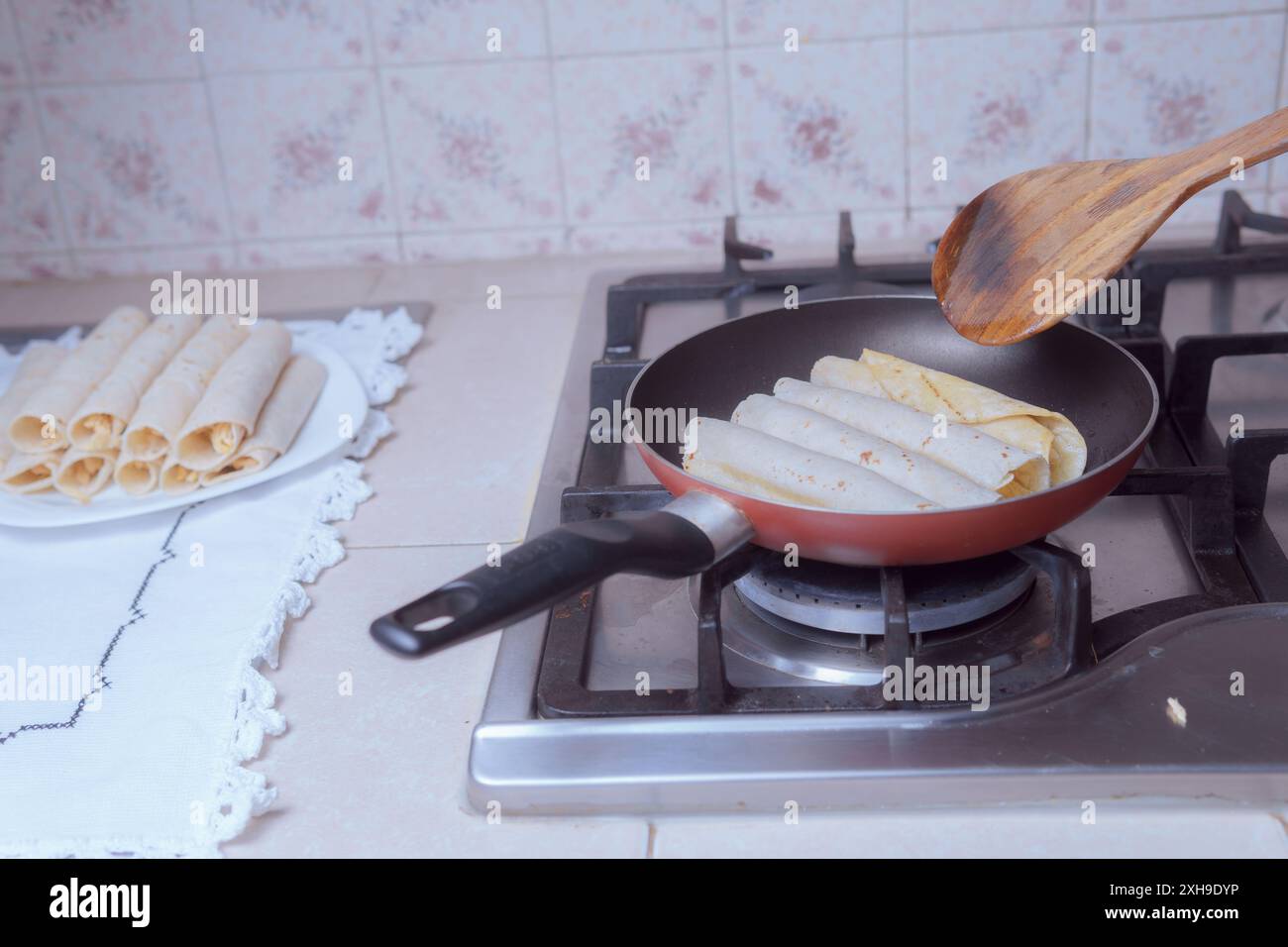 Preparation of golden tacos in the frying pan, frying Mexican tacos ...
