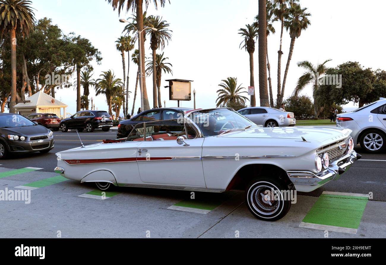 Low rider car driver showing off his hydraulic system near the ocean in ...