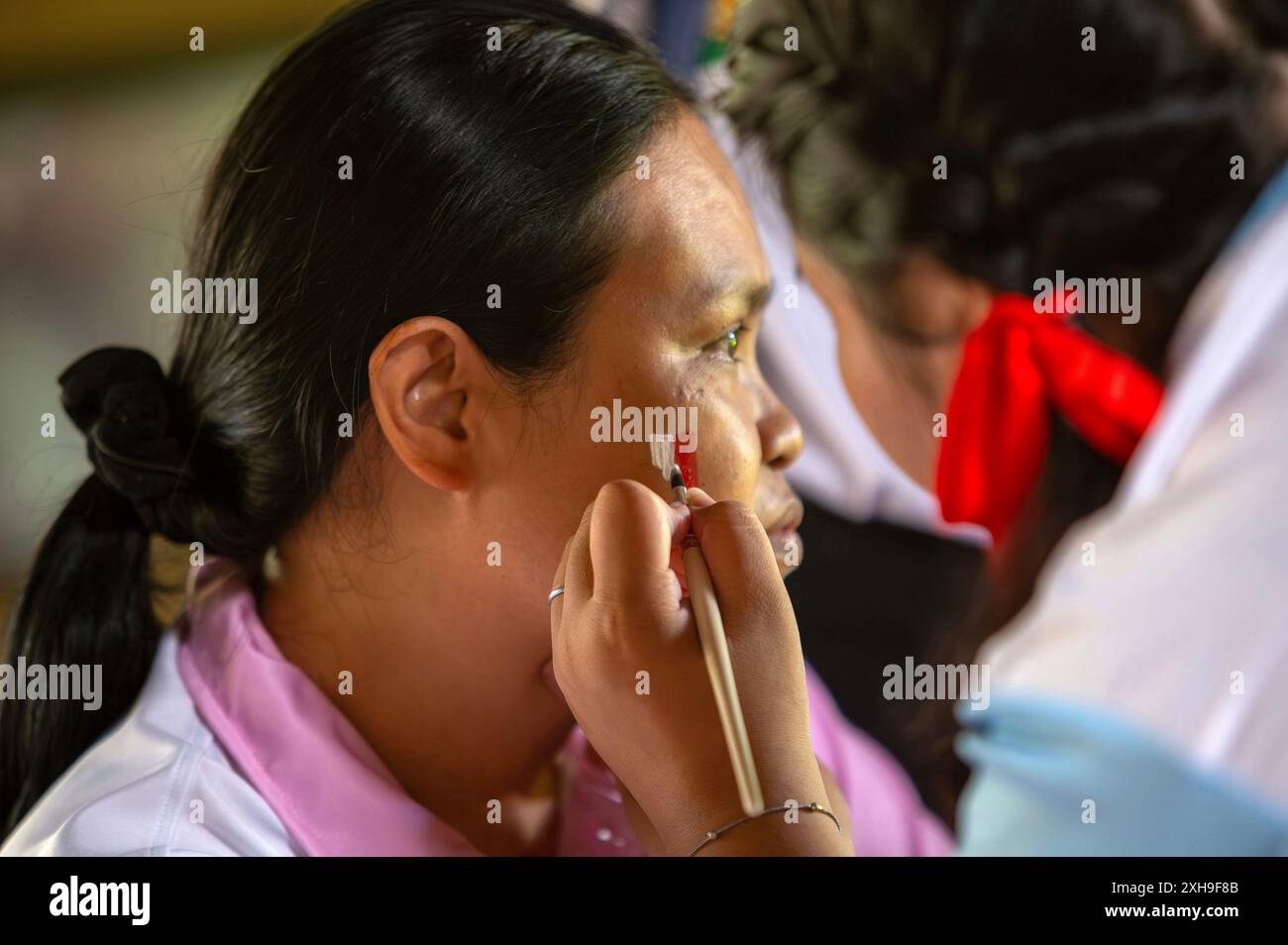 A Thai staff member of the Chiang Mai Night Safari is being painted ...