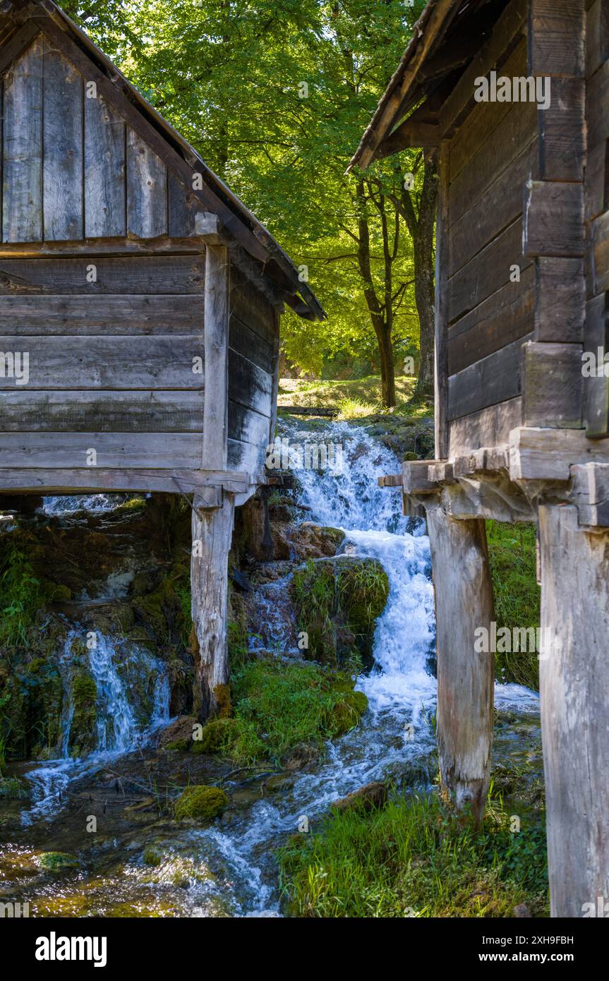 A small stream with crystal clear water flows over a steep slope ...