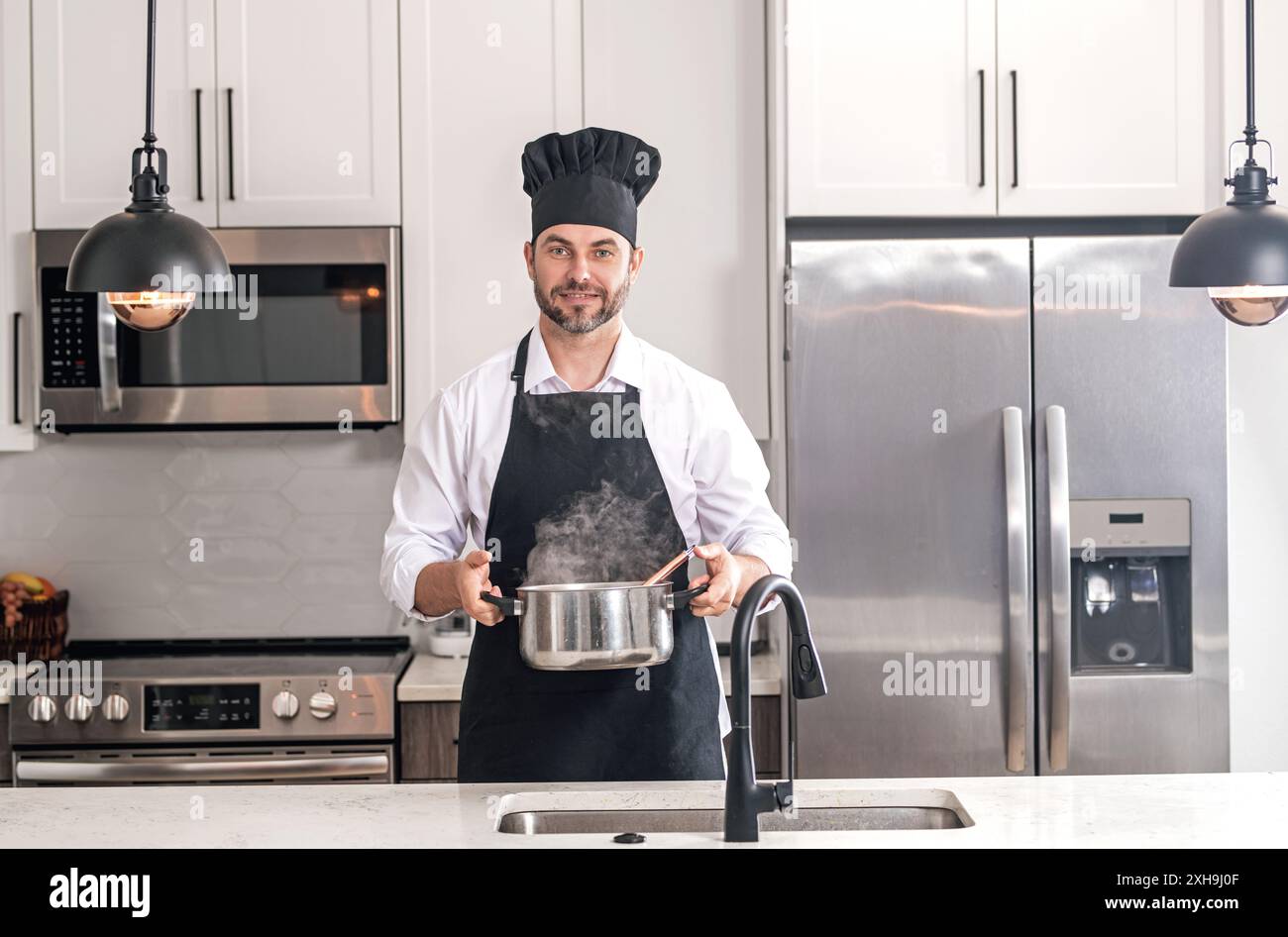 Male cook or chef cooking food in pan pot in kitchen. Process of ...