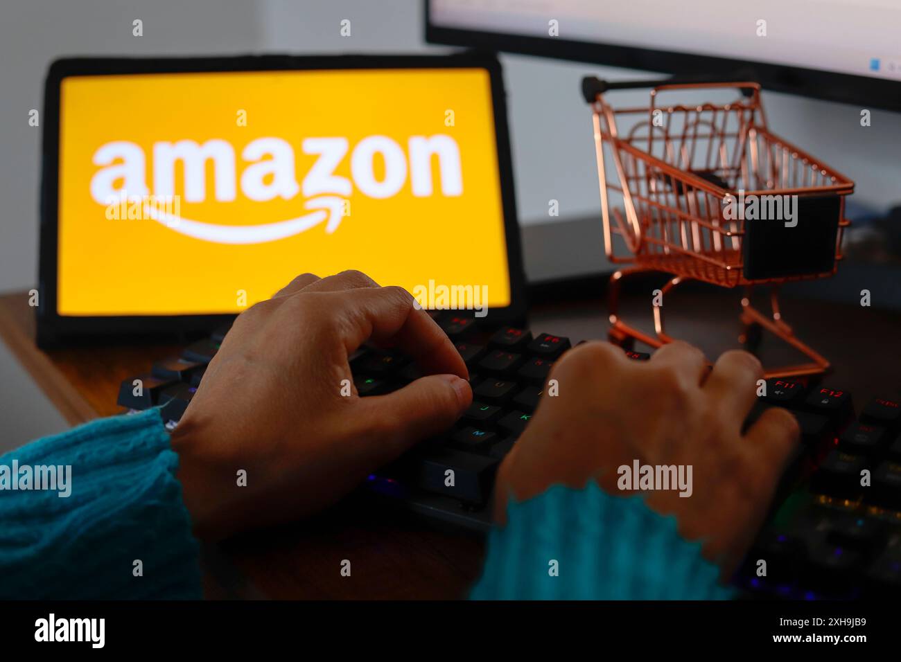 In this photo illustration, a person types near the Amazon logo is ...