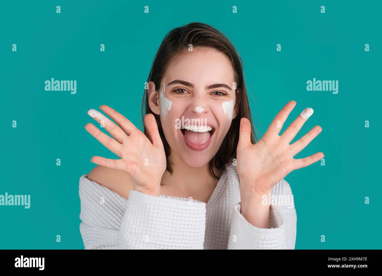 Beautiful amazed woman applying face cream, female skin care, close up ...