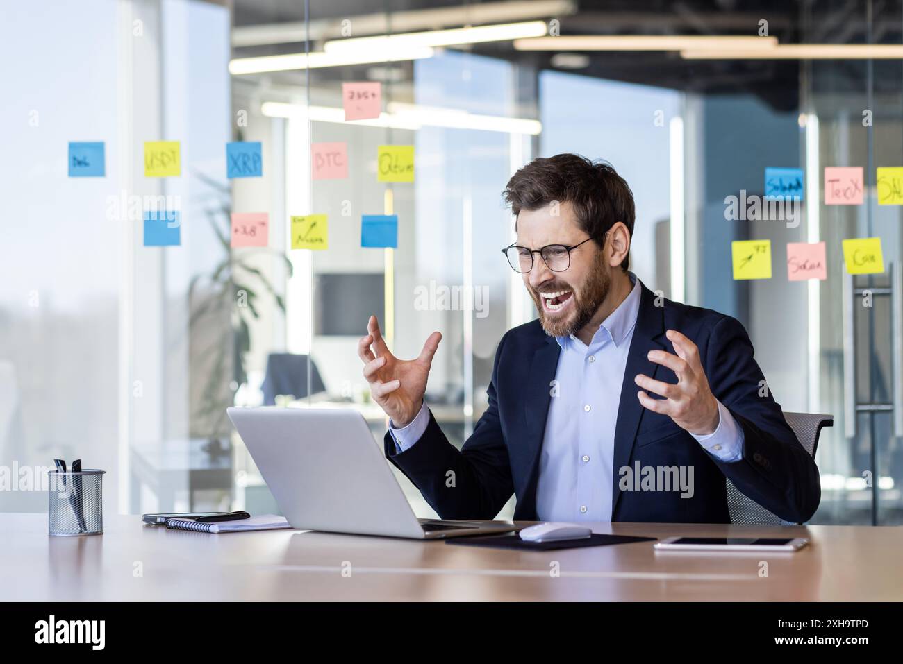 Angry man in business suit yelling at laptop screen inside office ...