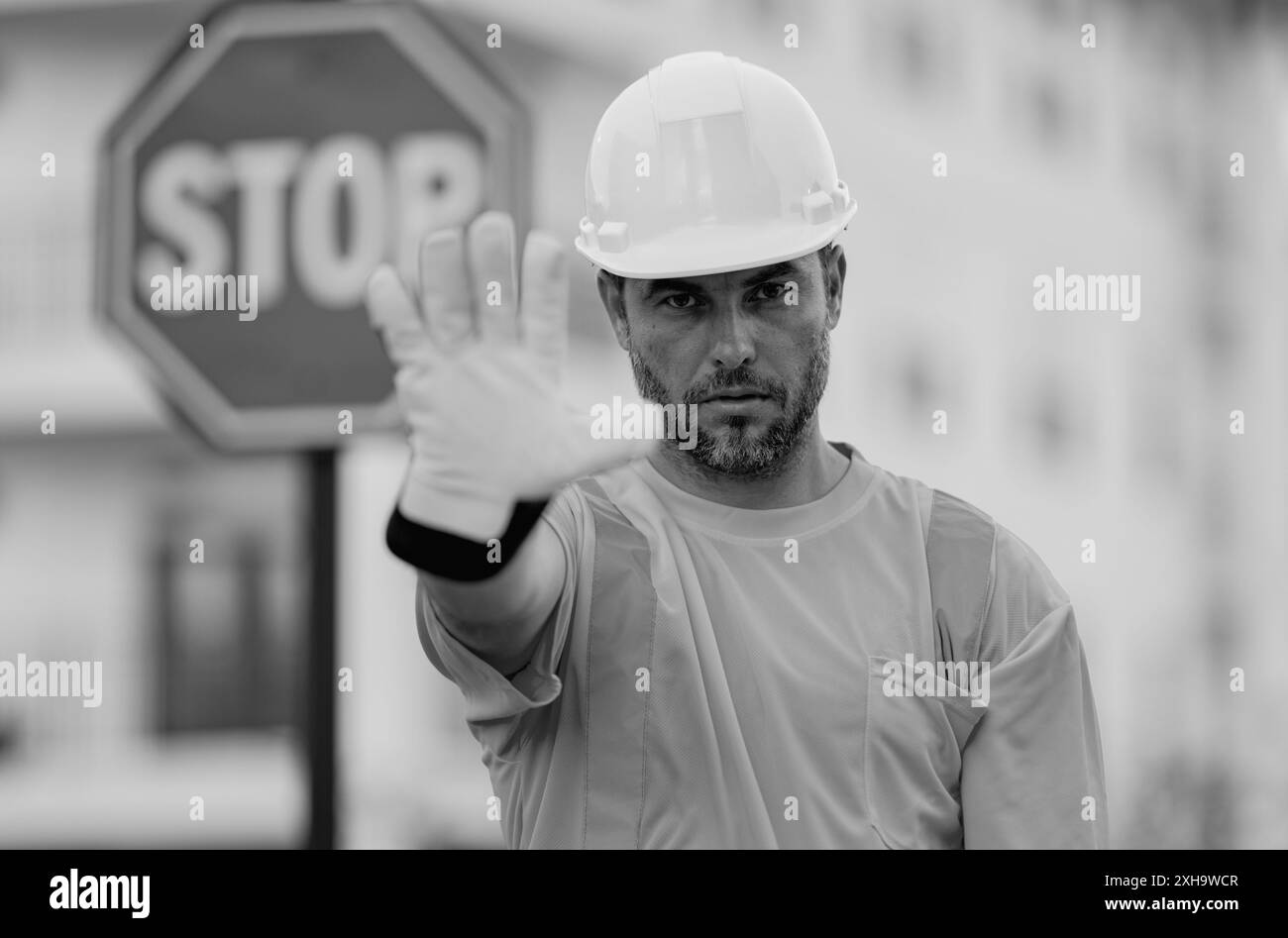 Serious engineer with stop road sign. Builder with stop gesture, no ...