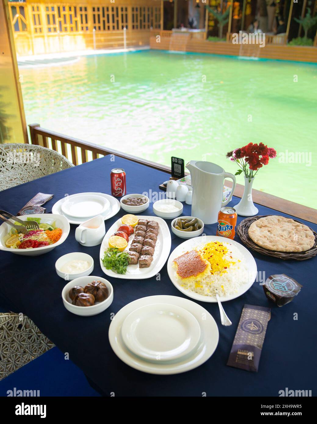 Delicious Iranian cuisine by the poolside, featuring kebabs, saffron rice, fresh salad, and ...